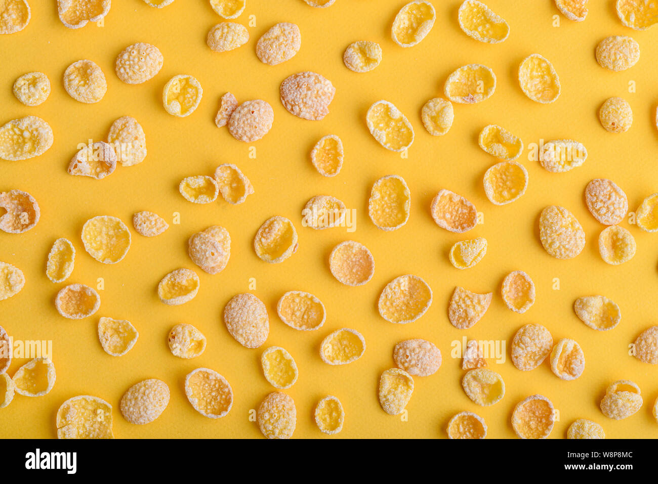 Corn flakes pattern on yellow background, top view Stock Photo - Alamy