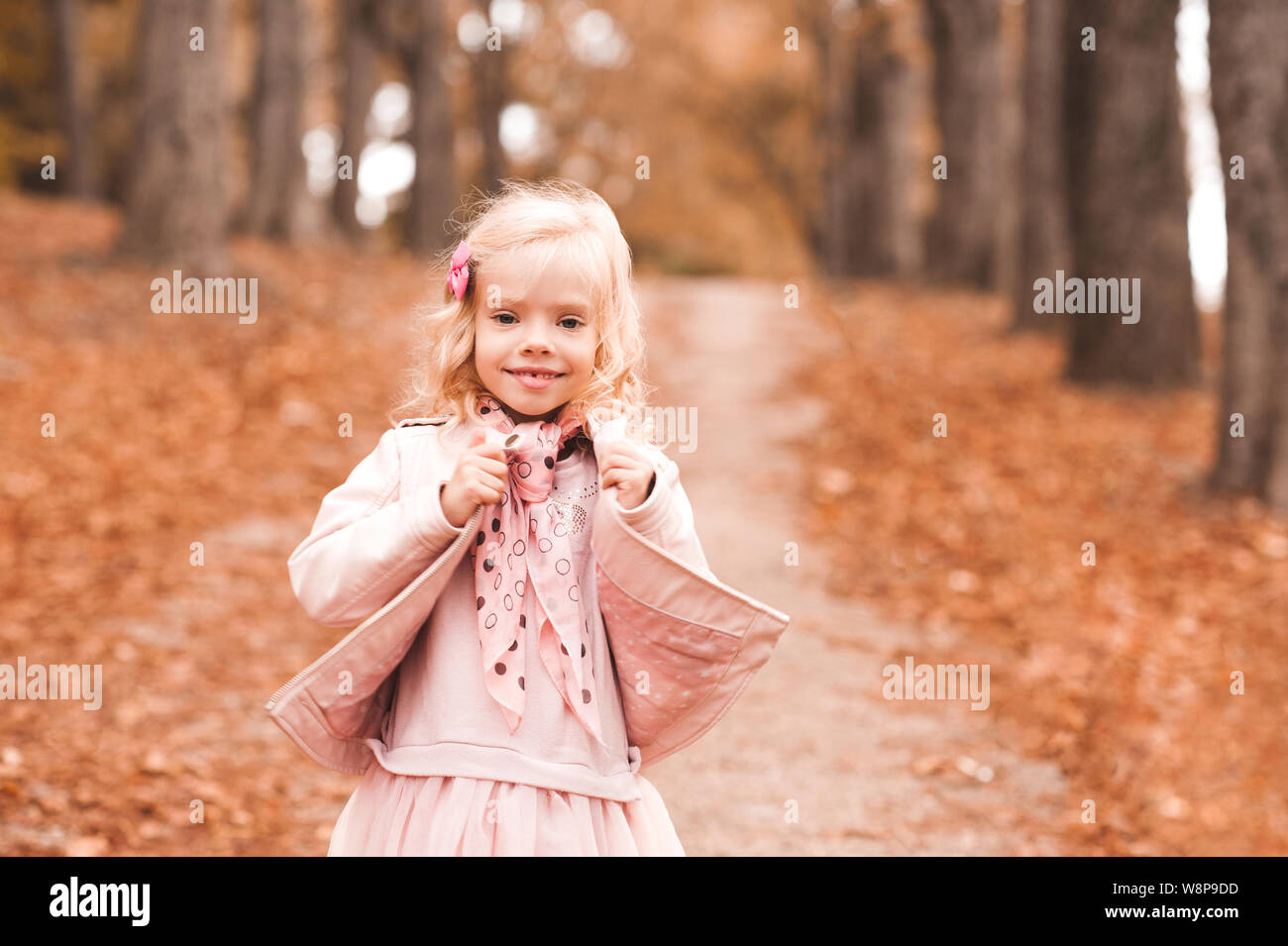 Happy kid girl 4-5 year old wearing stylish clothes in autumn park ...