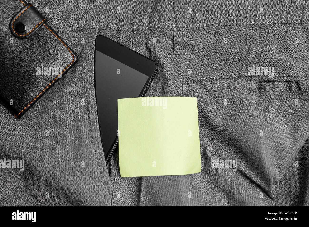 Smartphone device inside trousers front pocket with wallet and note ...