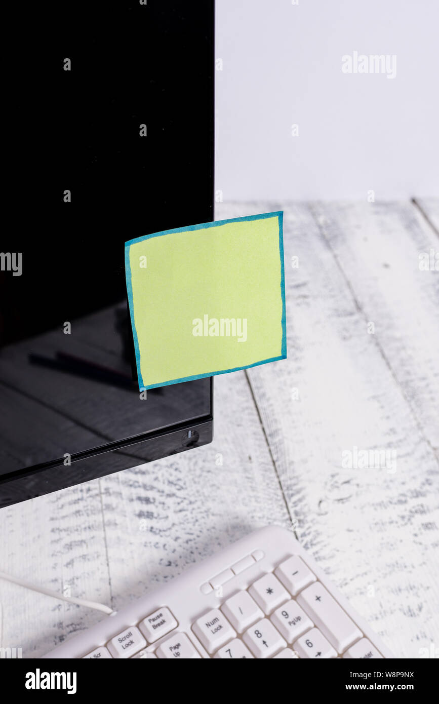 Notation paper taped to black computer monitor screen near white ...