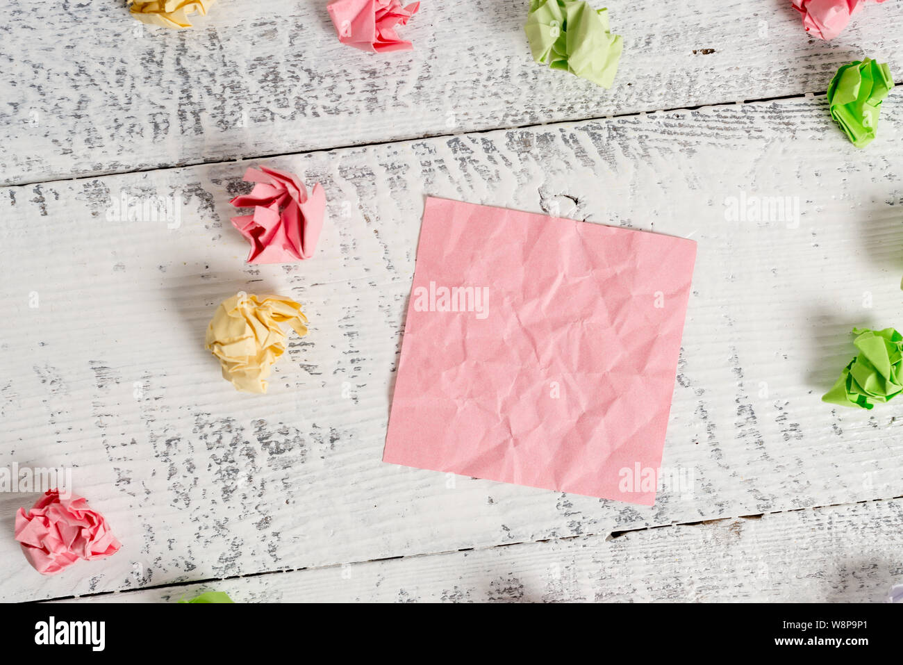 Crumpled colored rectangle square shaped paper reminder white wood desk ...