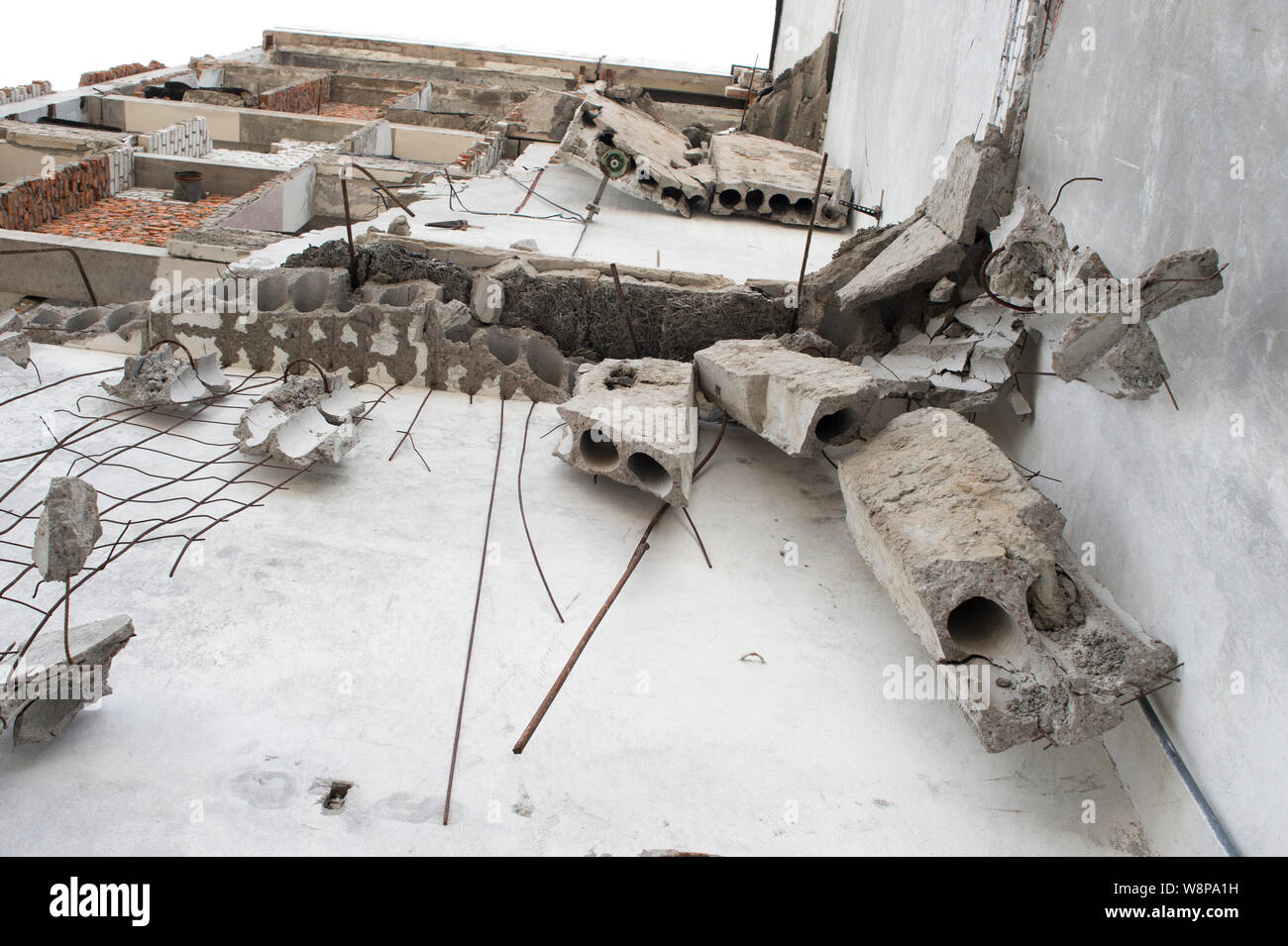Concrete fragments hang on the reinforcement on the wall of the ...