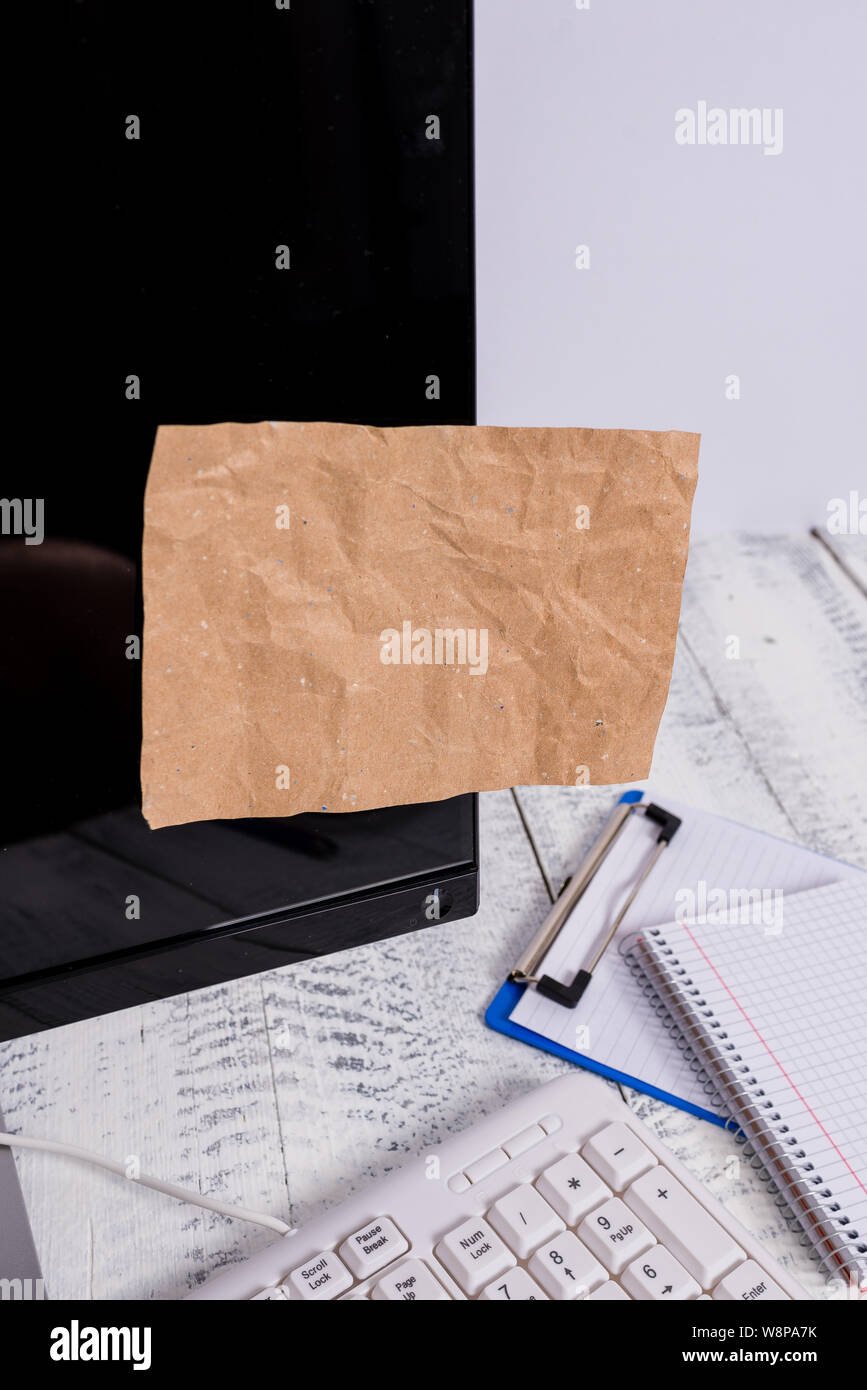 Note paper taped to black computer screen near keyboard and stationary ...