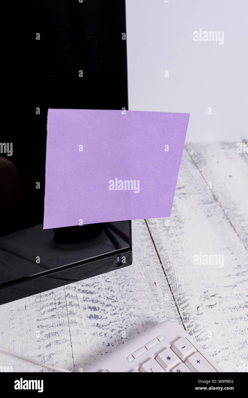 Notation paper taped to black computer monitor screen near white ...