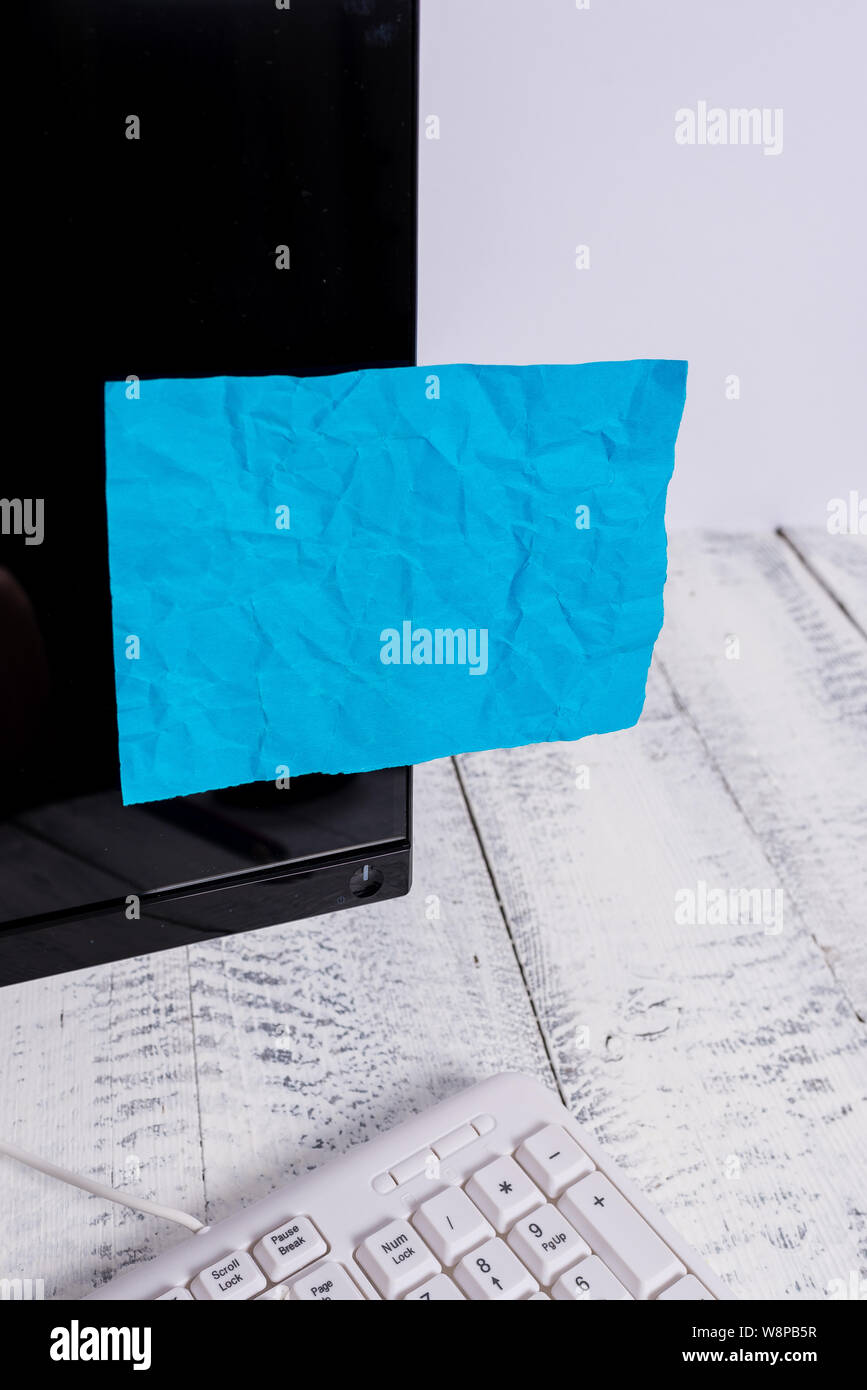 Notation paper taped to black computer monitor screen near white ...