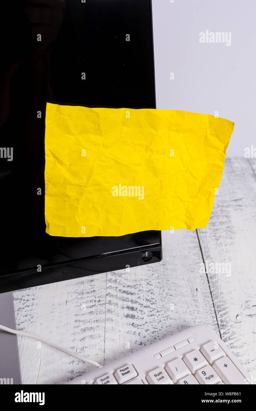 Notation paper taped to black computer monitor screen near white ...