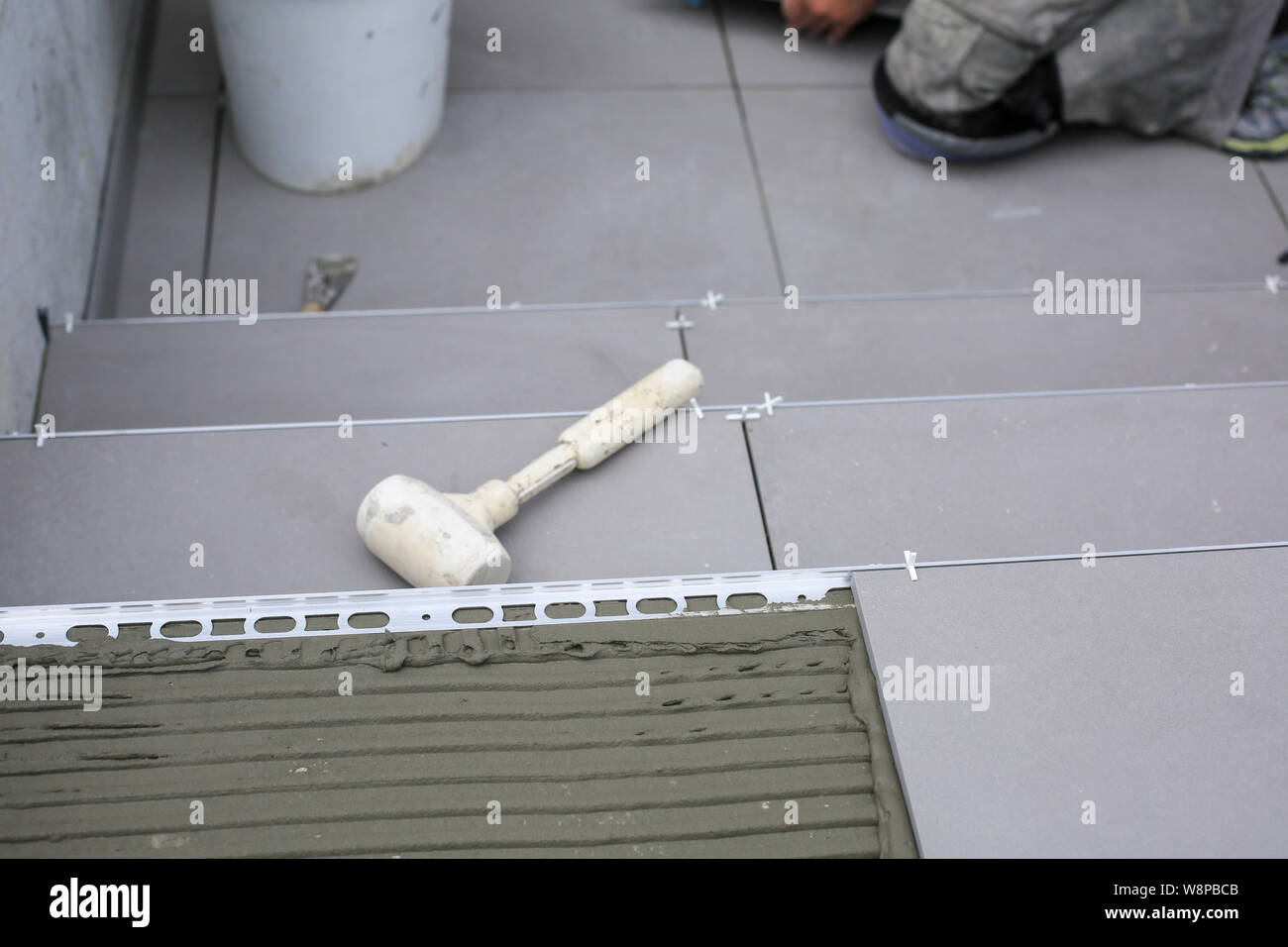 Tiler hands working on a new house entrance, local and professional ...