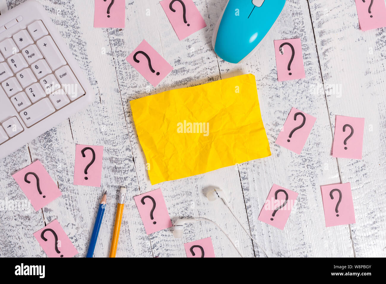 Writing tools, computer stuff and scribbled paper on top of wooden ...
