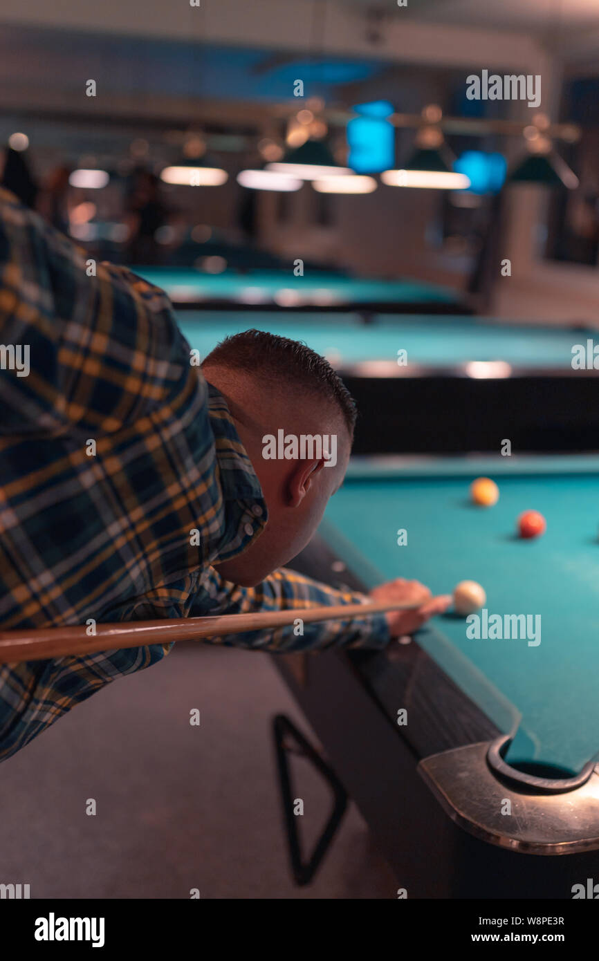 young guy from behind play billard pool at night Stock Photo - Alamy