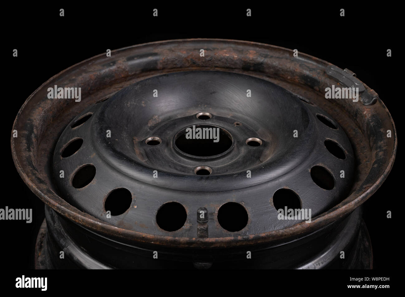 Old black metal rim on a workbench. Rusty car accessories. Dark ...