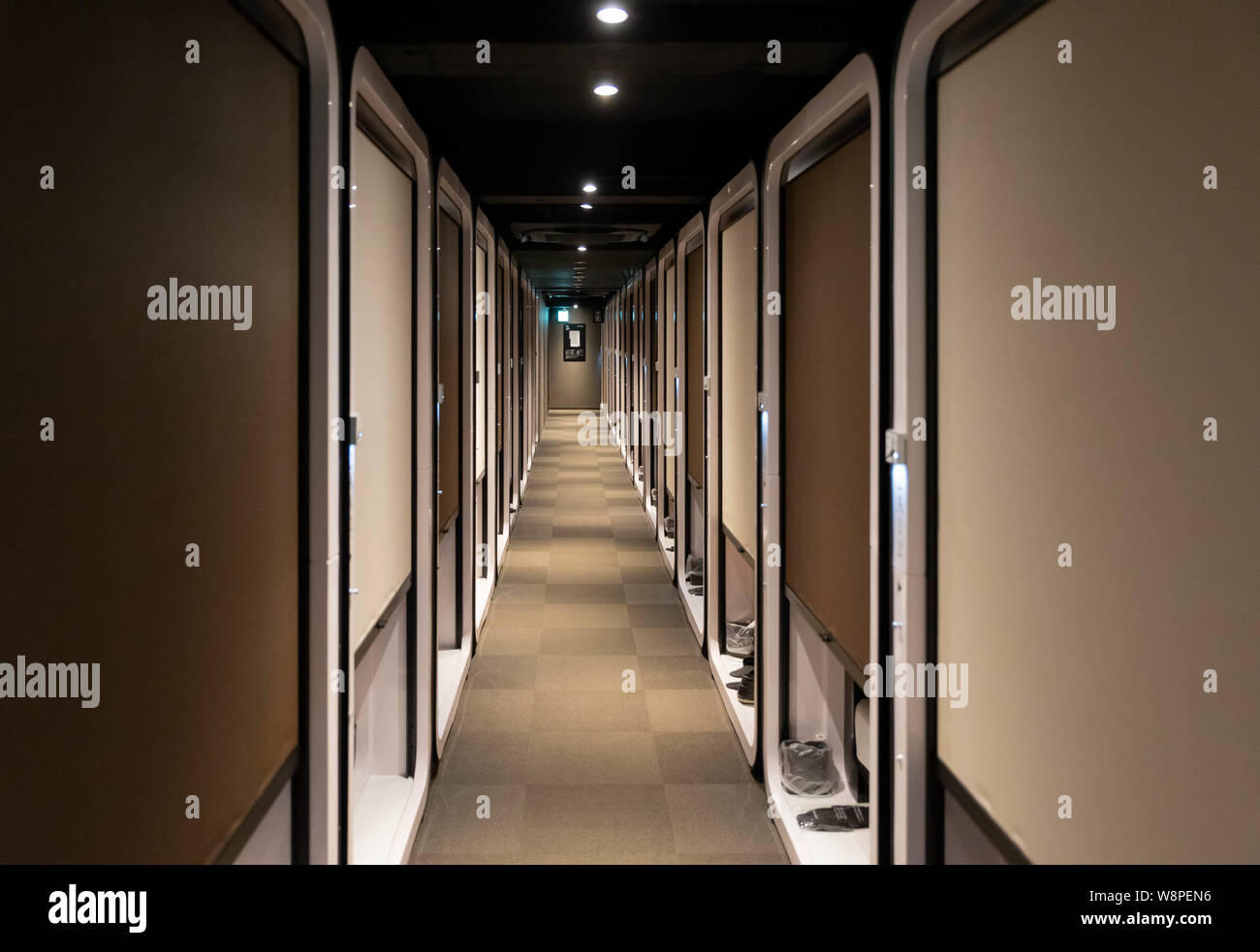 Cabins line narrow hallway in Japanese capsule hotel Stock Photo - Alamy