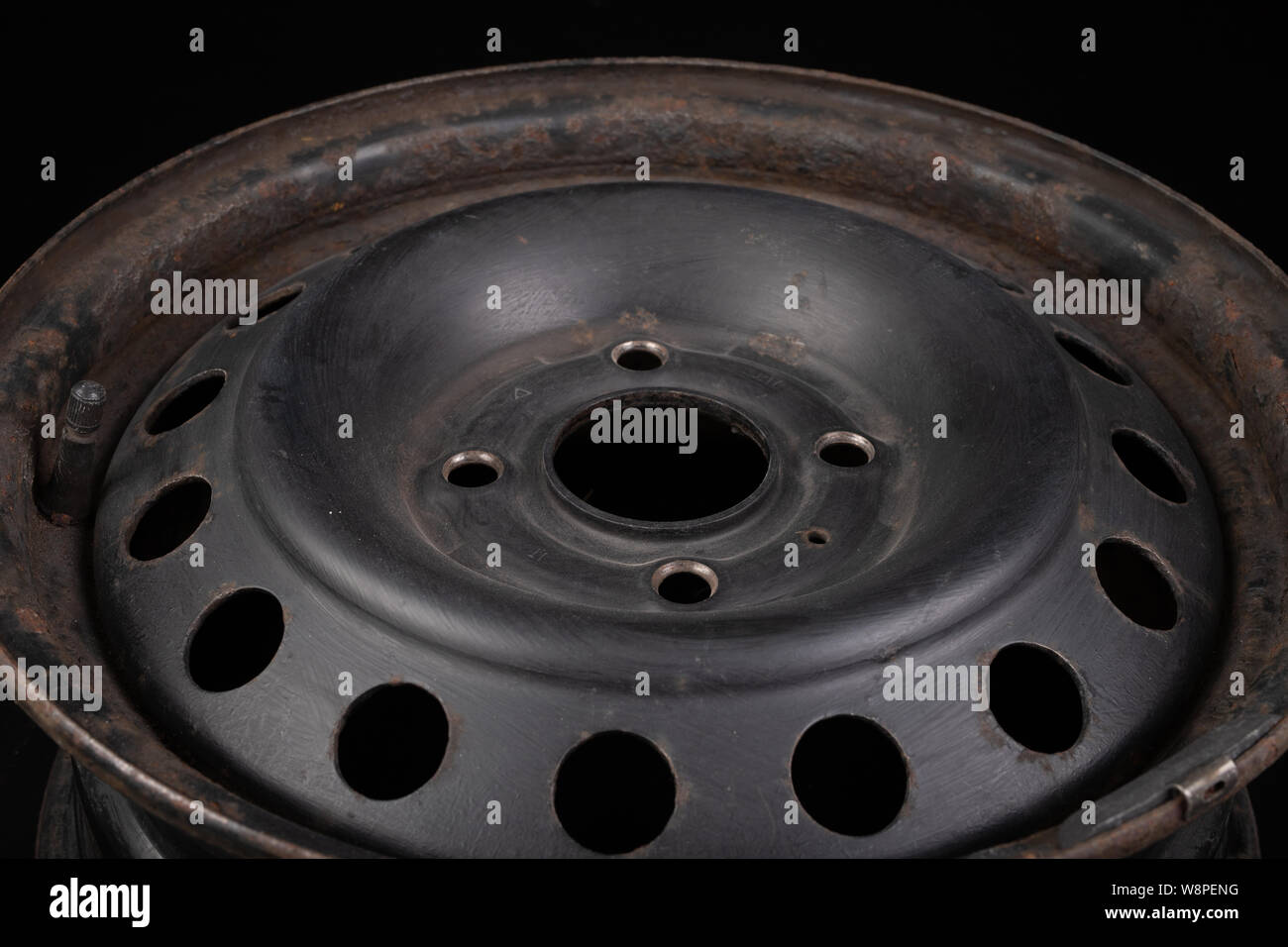 Old black metal rim on a workbench. Rusty car accessories. Dark ...