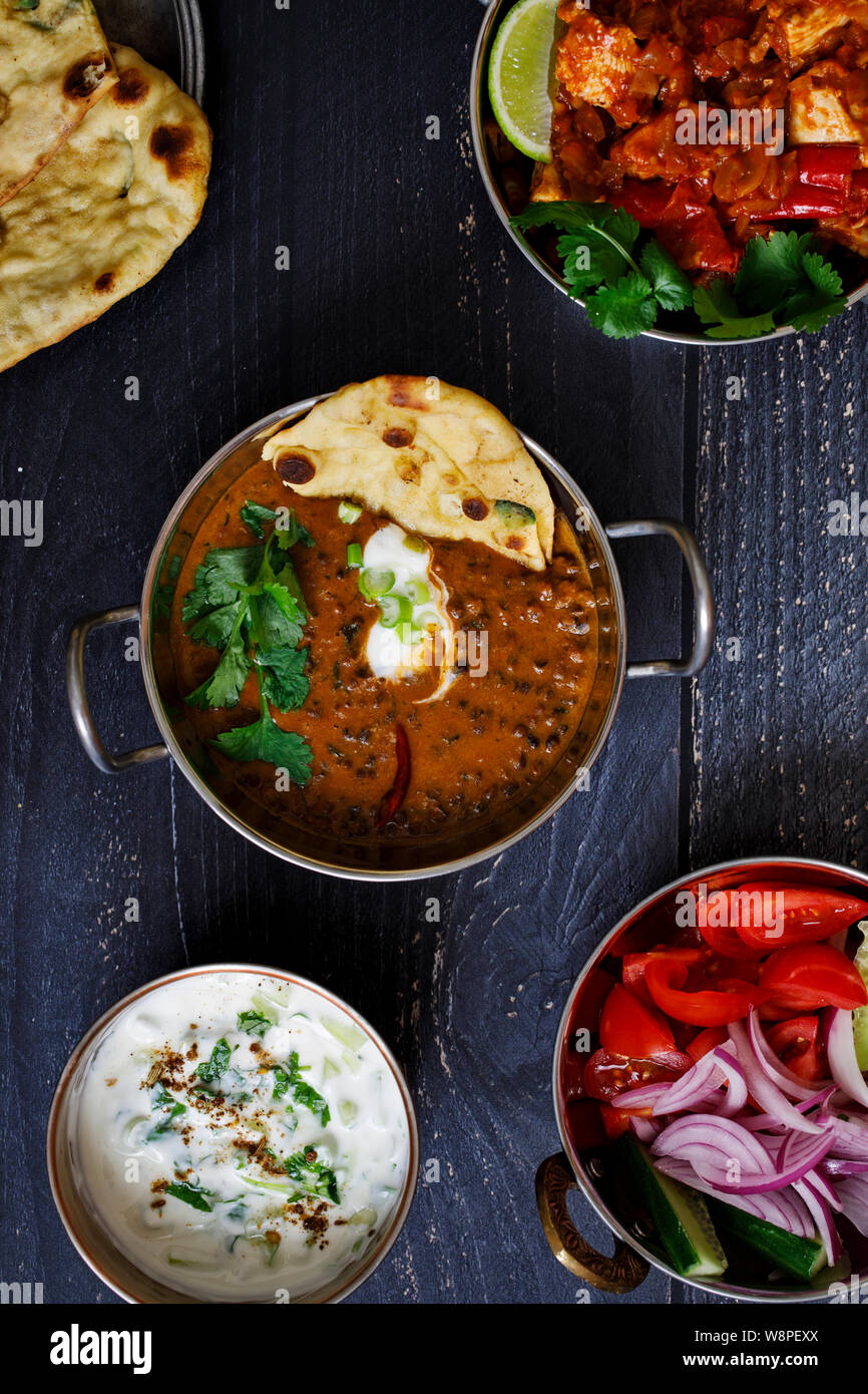 Indian curry meal with black lentils dal, spicy potatoes, rice, naan ...