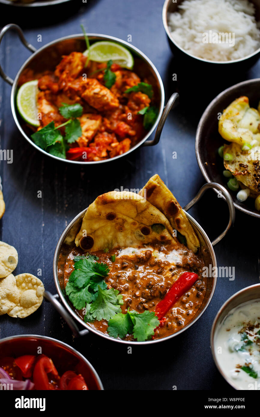Indian curry meal with black lentils dal, spicy potatoes, rice, naan ...