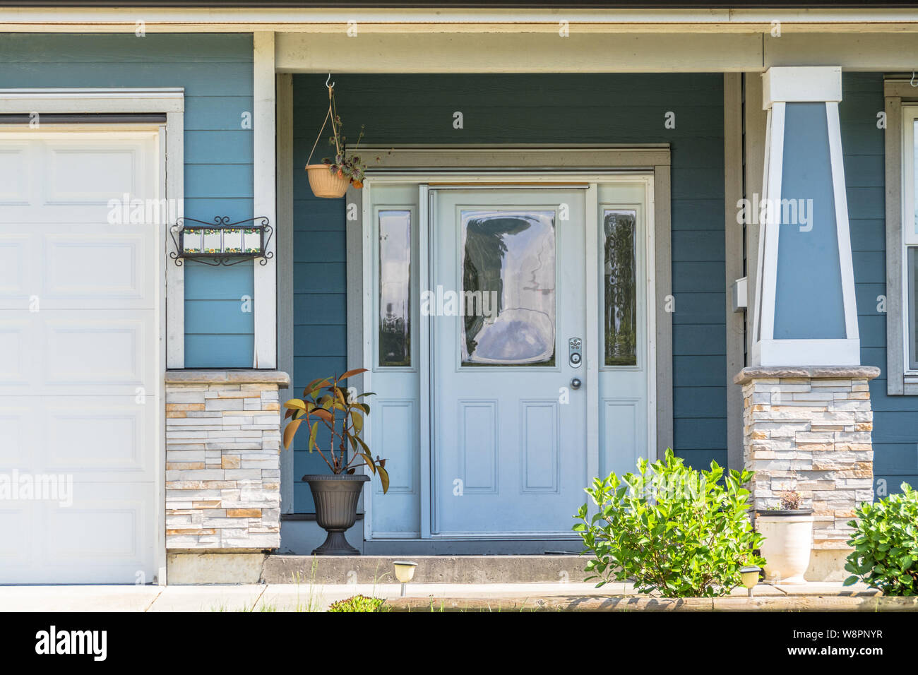 White door of residential house with dome shaped window and flower pots ...