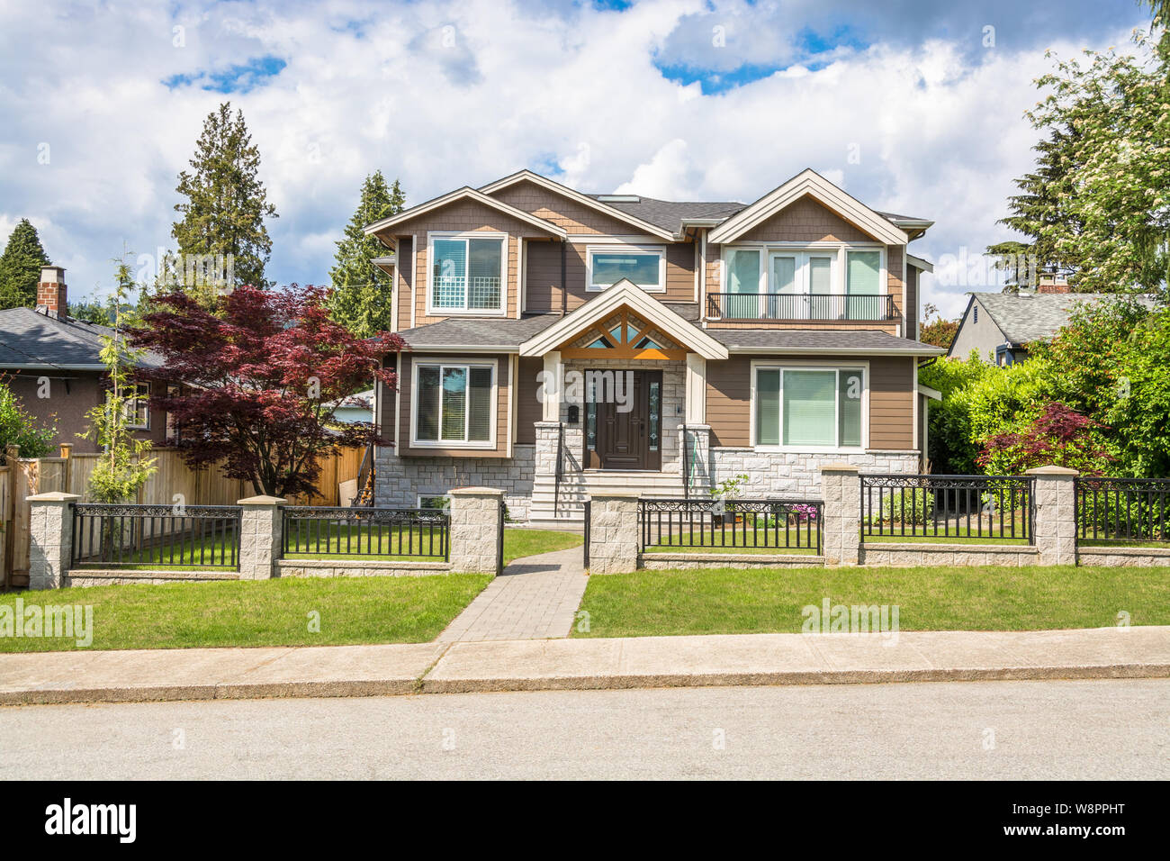 Modern luxury residential house with tile paved pathway on cloudy sky ...