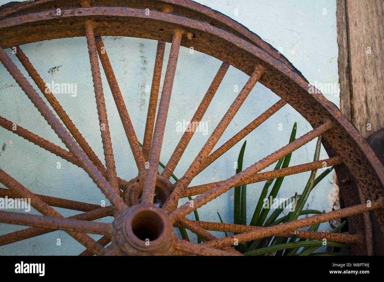 Rusted wheel leaning on a white painted wall Stock Photo - Alamy