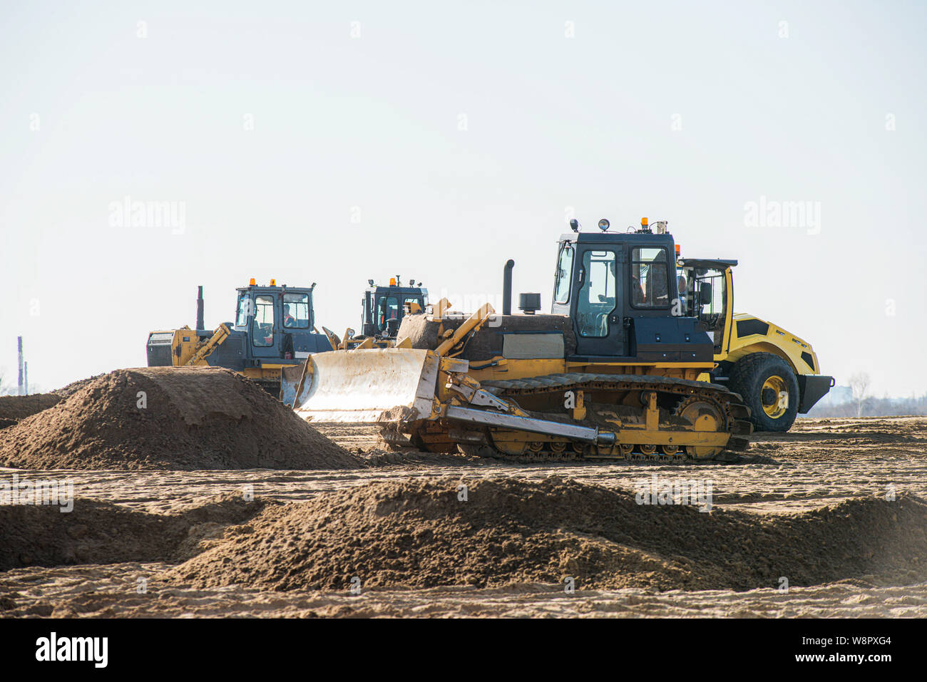 heavy duty machinery working on highway construction site. Bulldozer ...