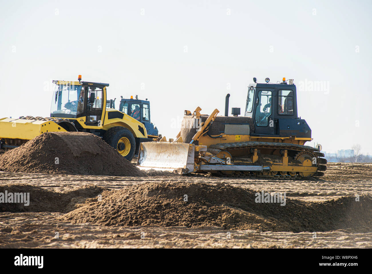 heavy duty machinery working on highway construction site. Bulldozer ...