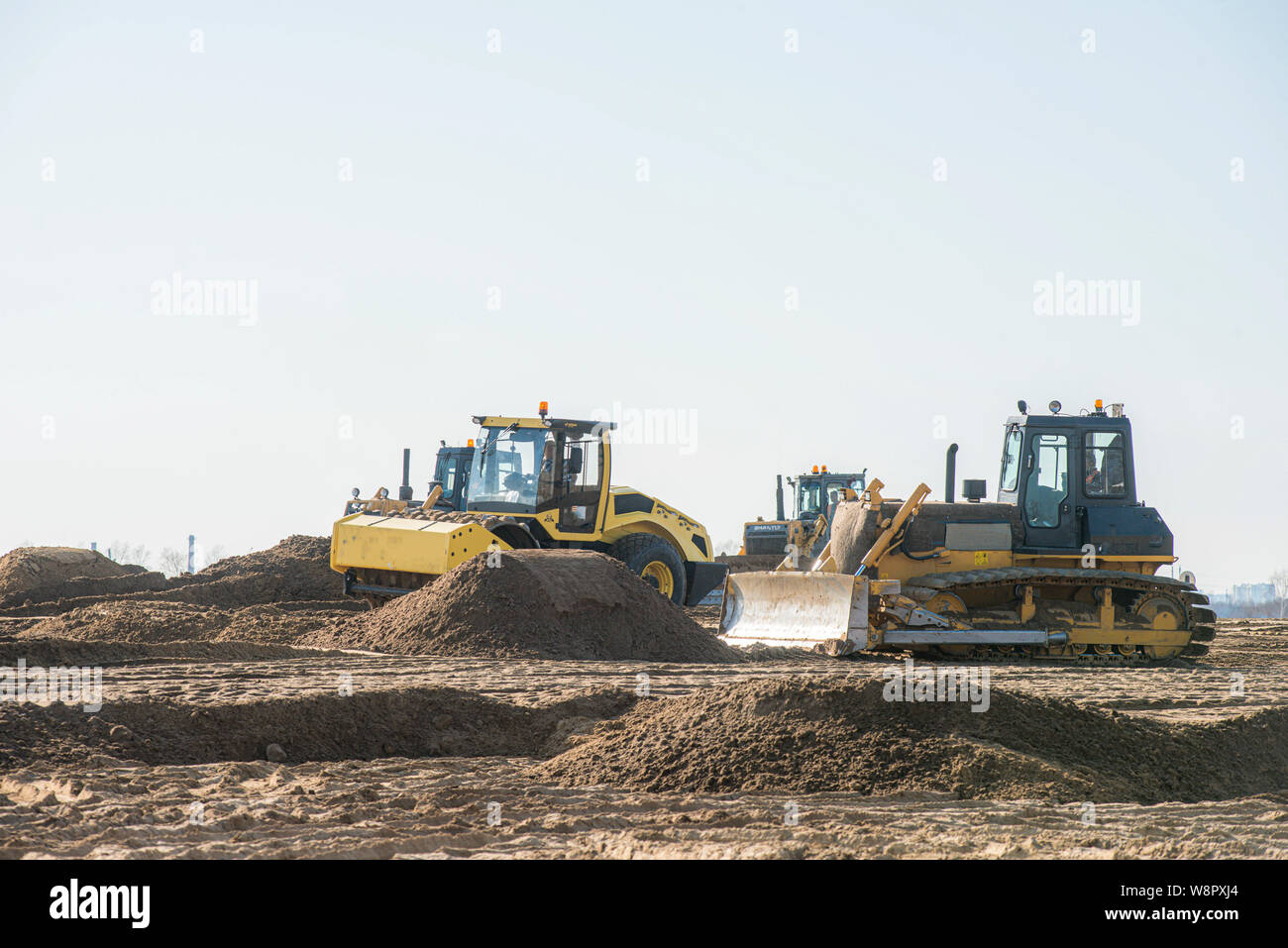 heavy duty machinery working on highway construction site. Bulldozer ...