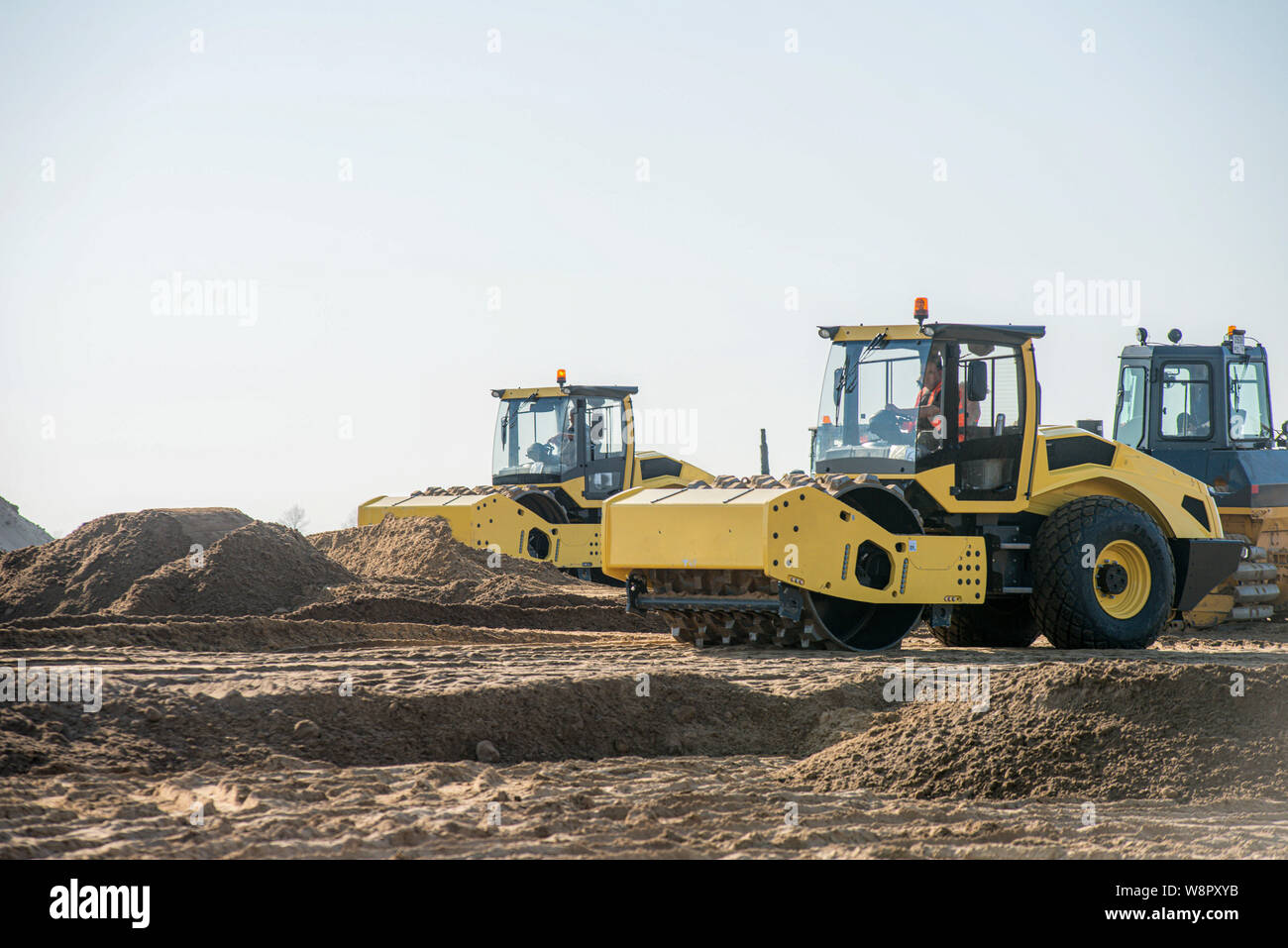 heavy duty machinery working on highway construction site. Bulldozer ...