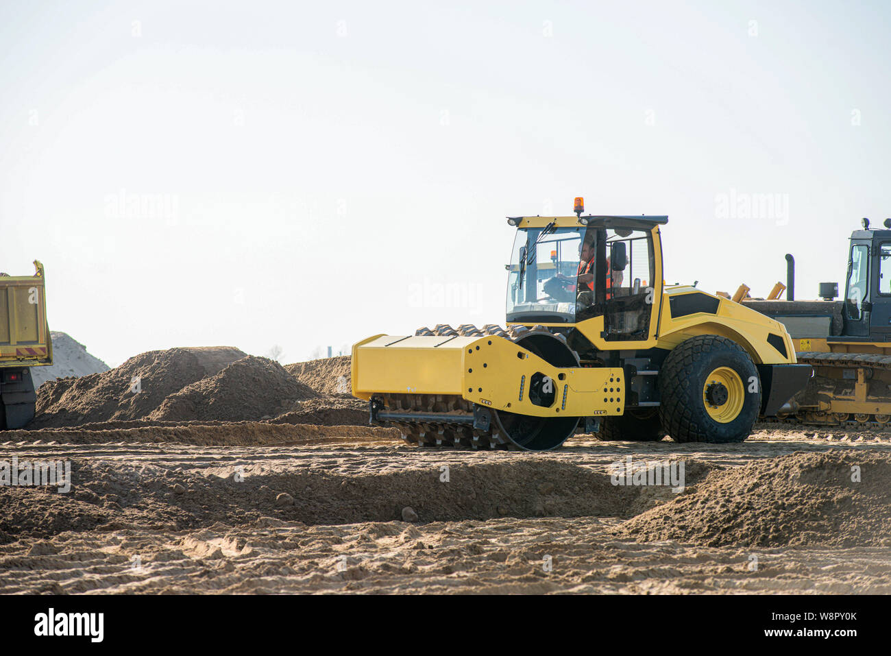heavy duty machinery working on highway construction site. Bulldozer ...