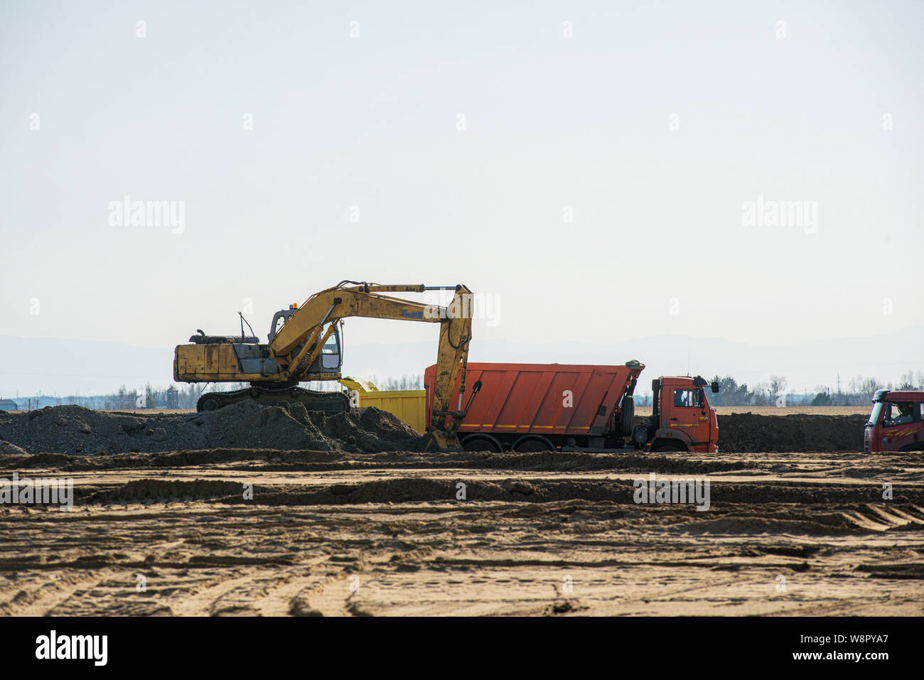 Excavator pours soil tipper truck hi-res stock photography and images ...