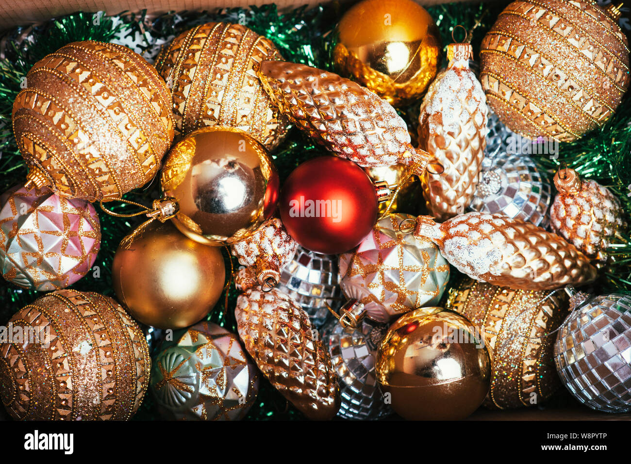 From above view of fragile Christmas decorations laid in pile in box ...