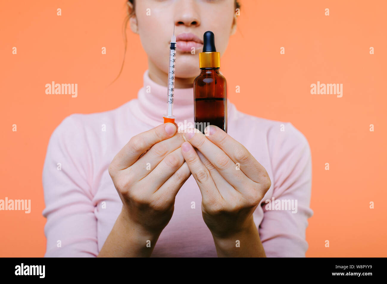 Crop young beautiful lady in blouse showing injection and bottle of ...