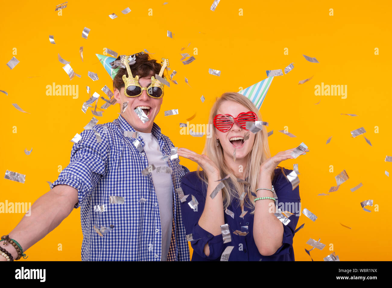 Fun, holidays and party concept - Couple dancing among falling confetti ...
