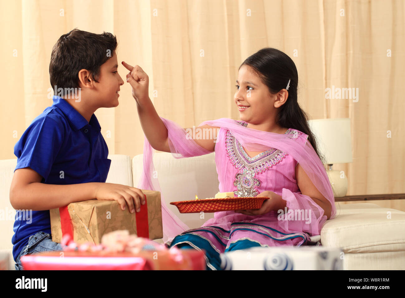 Girl applying tika on her brother forehead at Raksha Bandhan festival ...