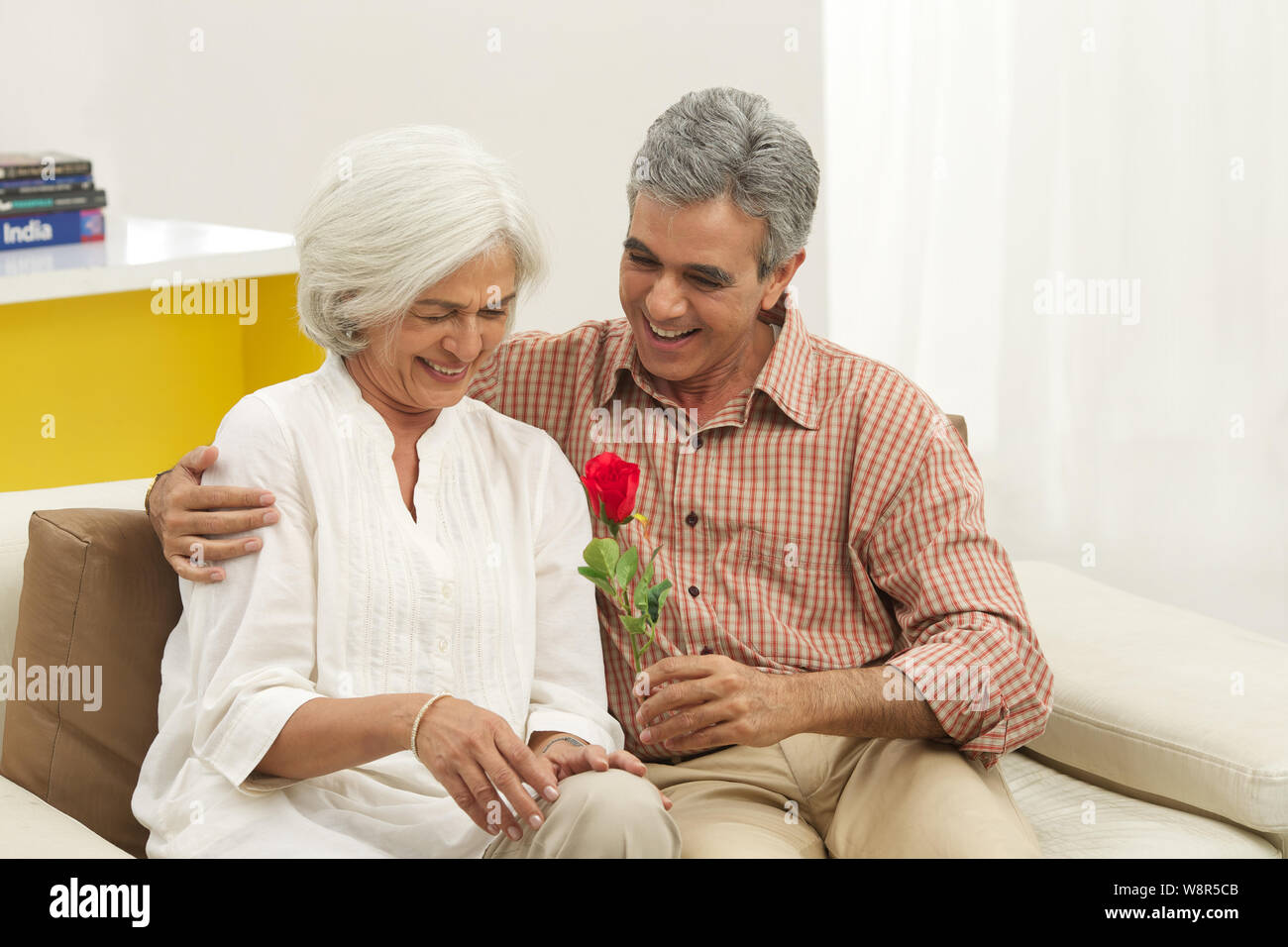 Senior man offering a rose to his wife and smiling Stock Photo - Alamy