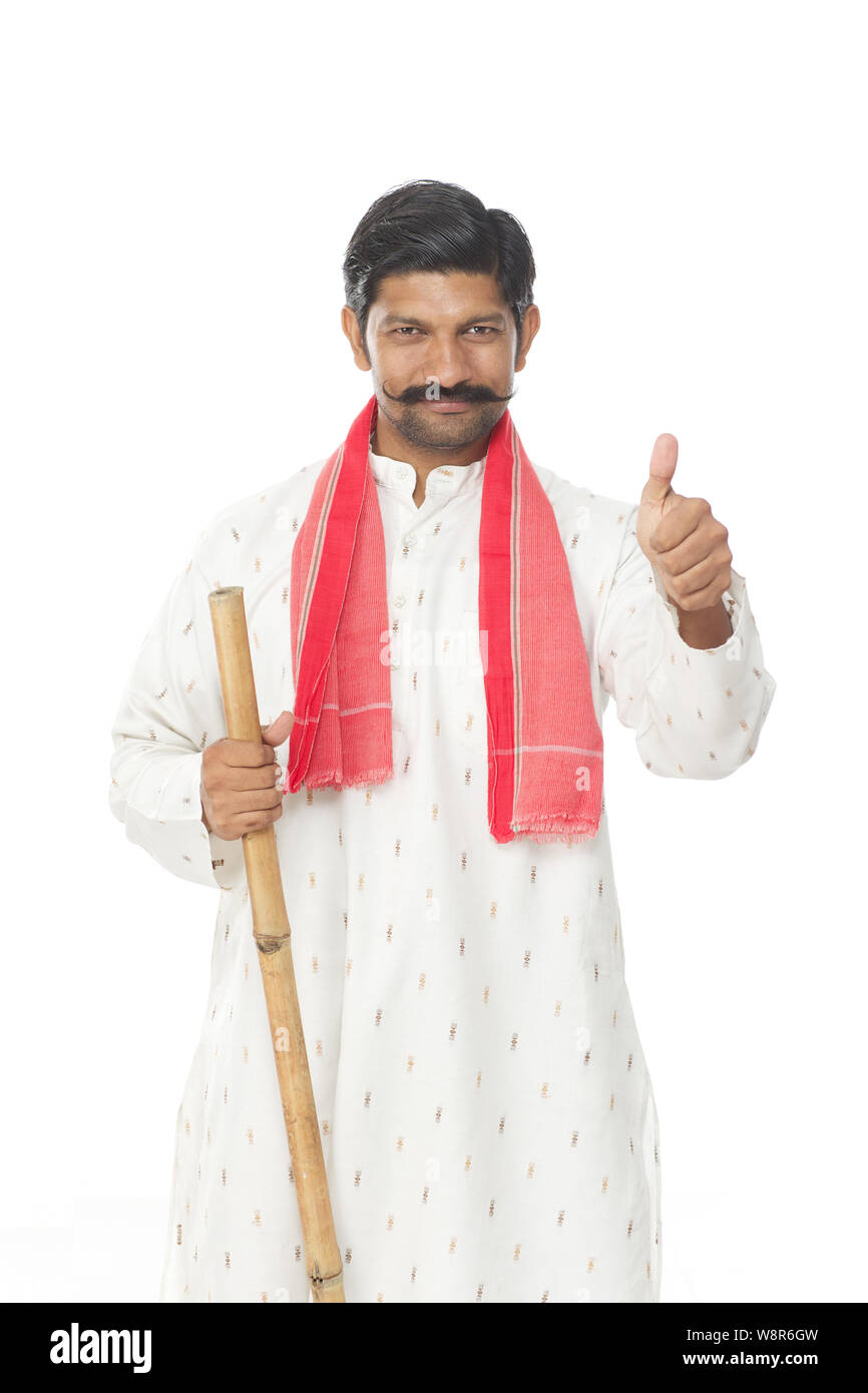 Rural man standing with his cane and showing thumbs up sign Stock Photo ...