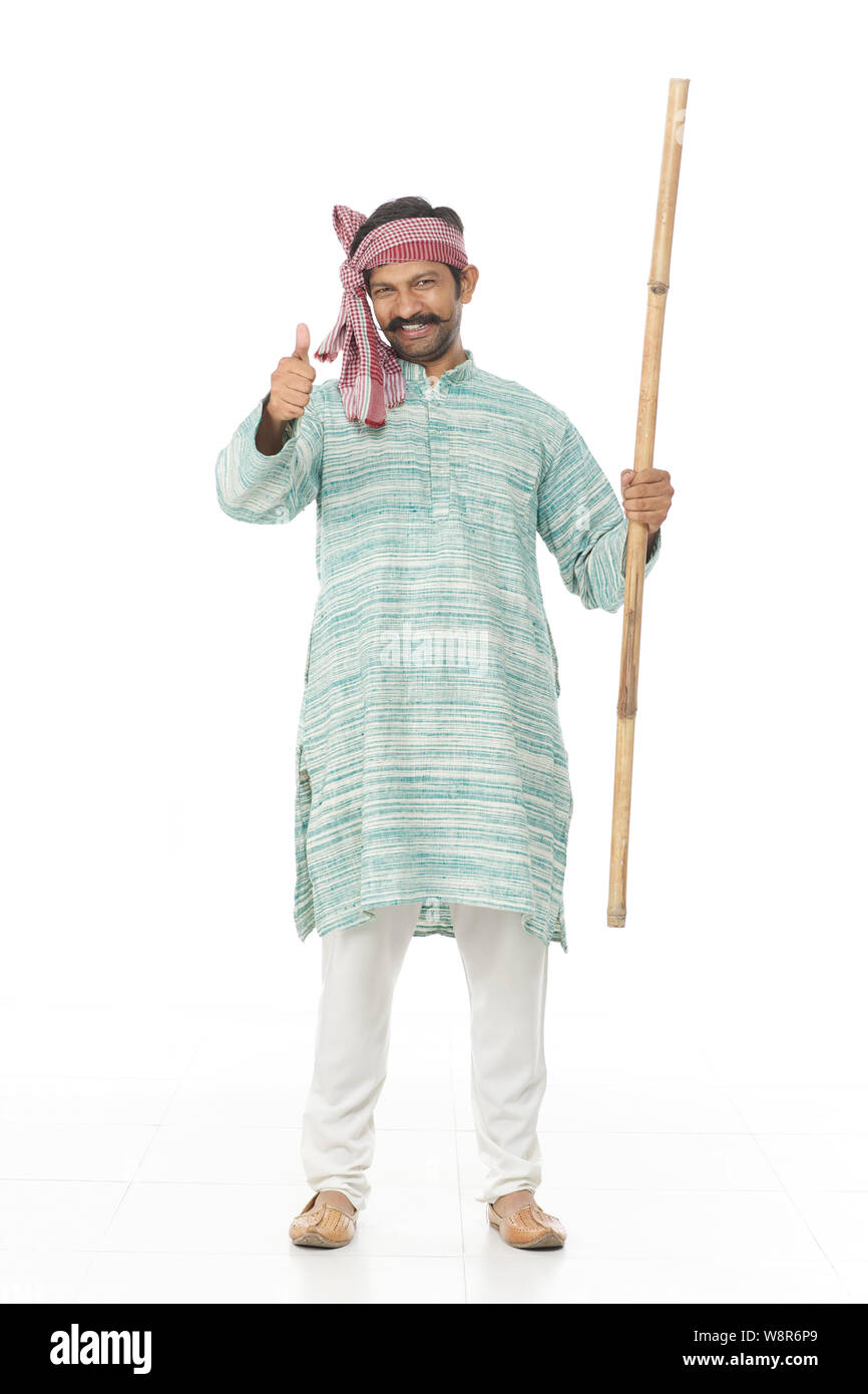 Rural man standing with his cane and showing thumbs up sign Stock Photo ...