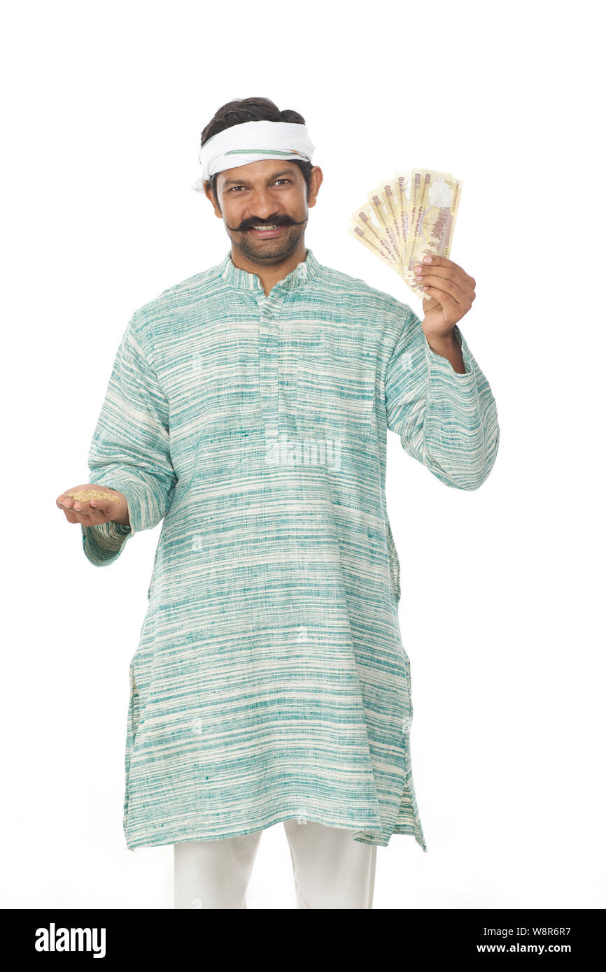 Rural man smiling and showing banknotes with wheat Stock Photo - Alamy