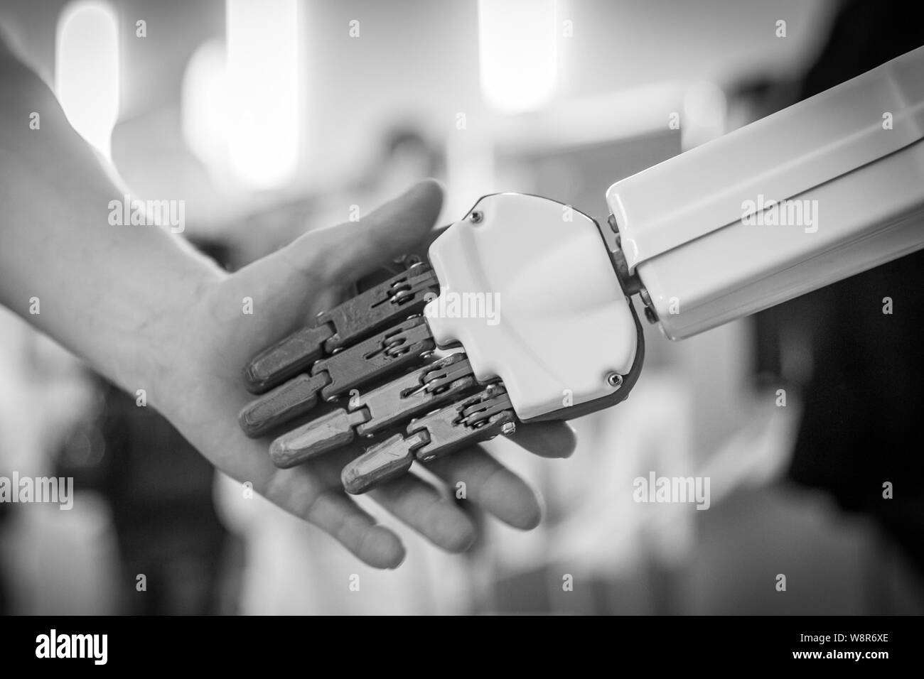close up of man shaking hands with a robot Stock Photo - Alamy
