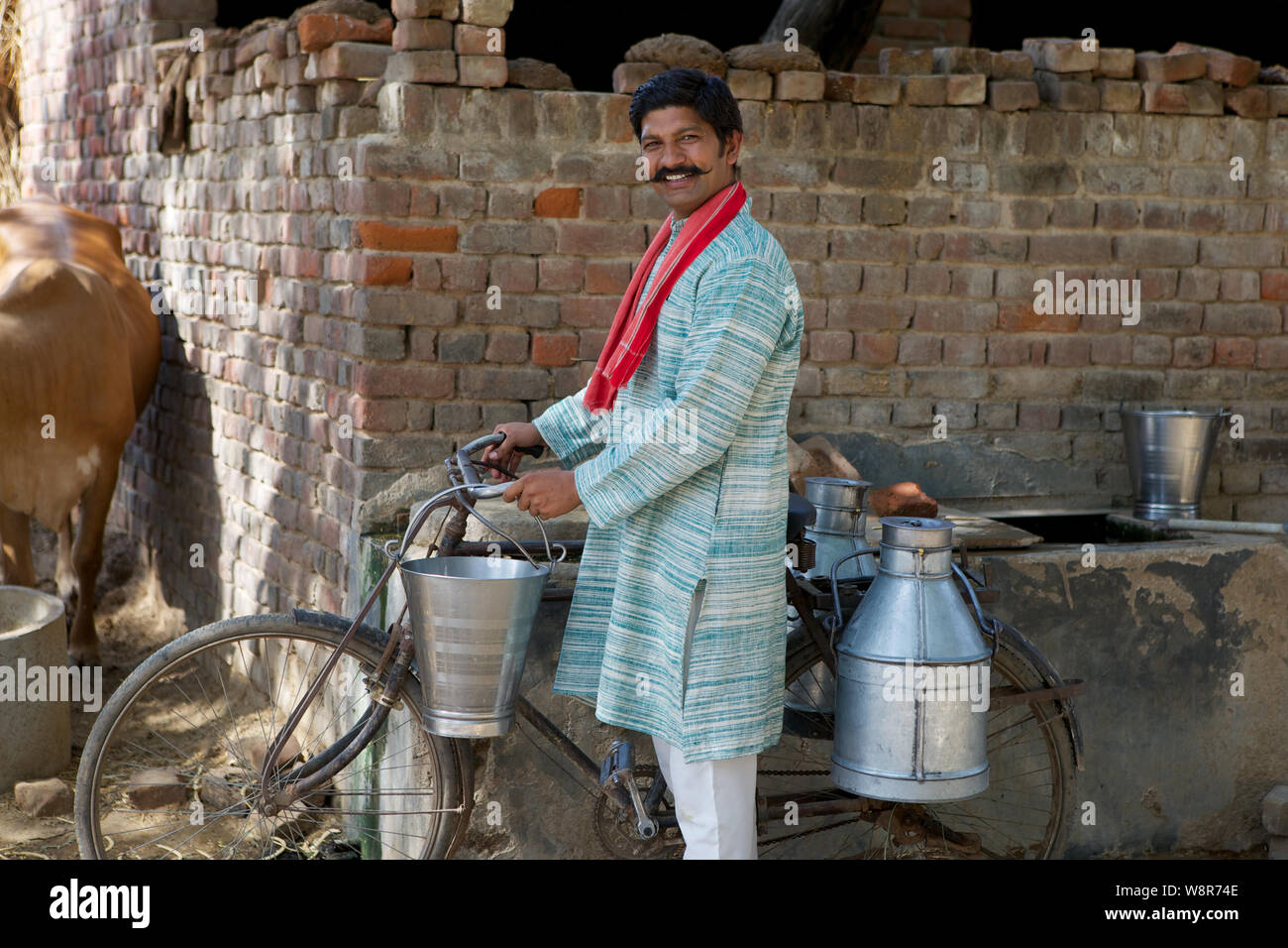 Milkman delivering milk on a cycle Stock Photo - Alamy