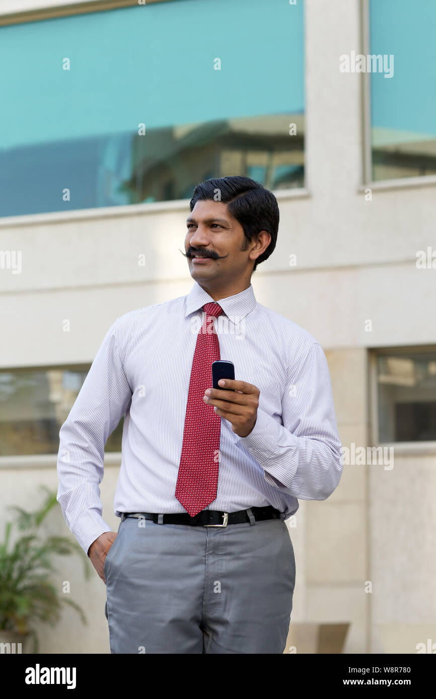 Mid adult businessman text messaging hi-res stock photography and ...