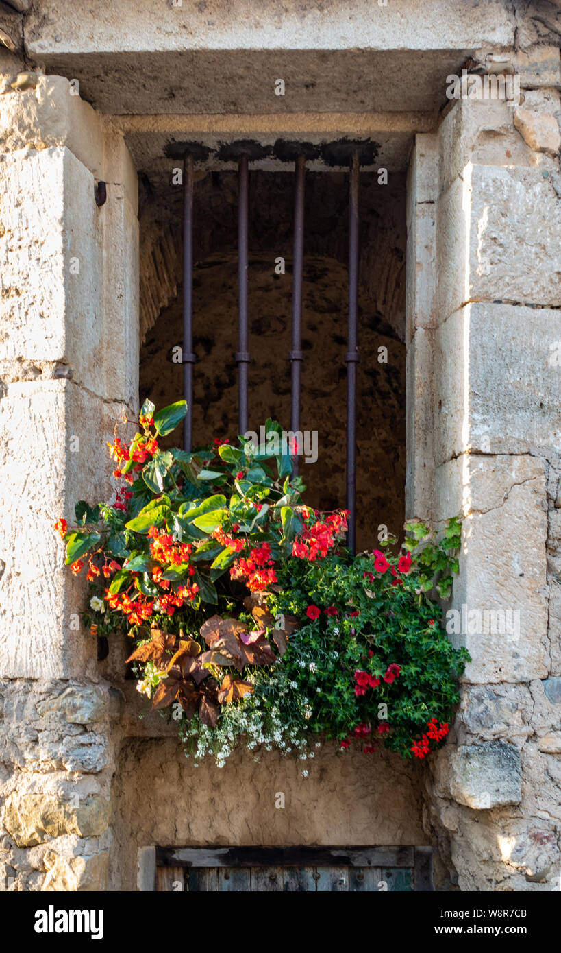Stone window recess with flowers and security bars Stock Photo - Alamy
