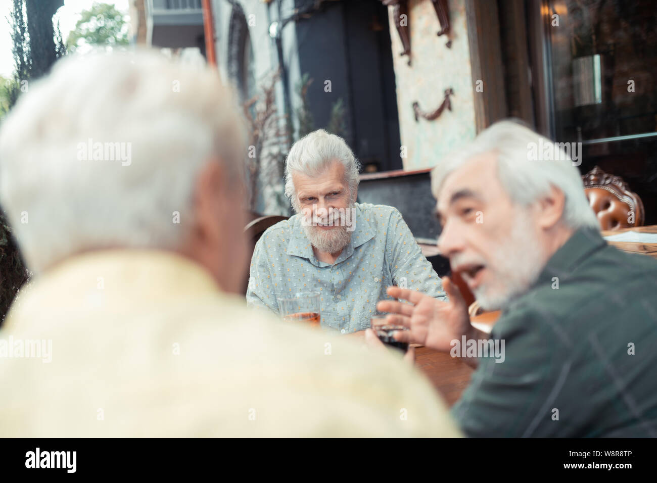 Retired men talking and drinking alcohol outside Stock Photo - Alamy