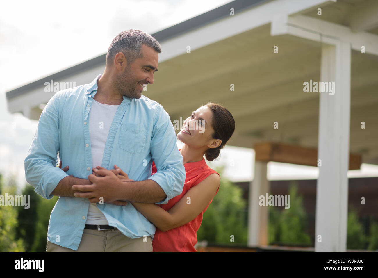 Loving beautiful wife hugging her strong handsome man Stock Photo - Alamy