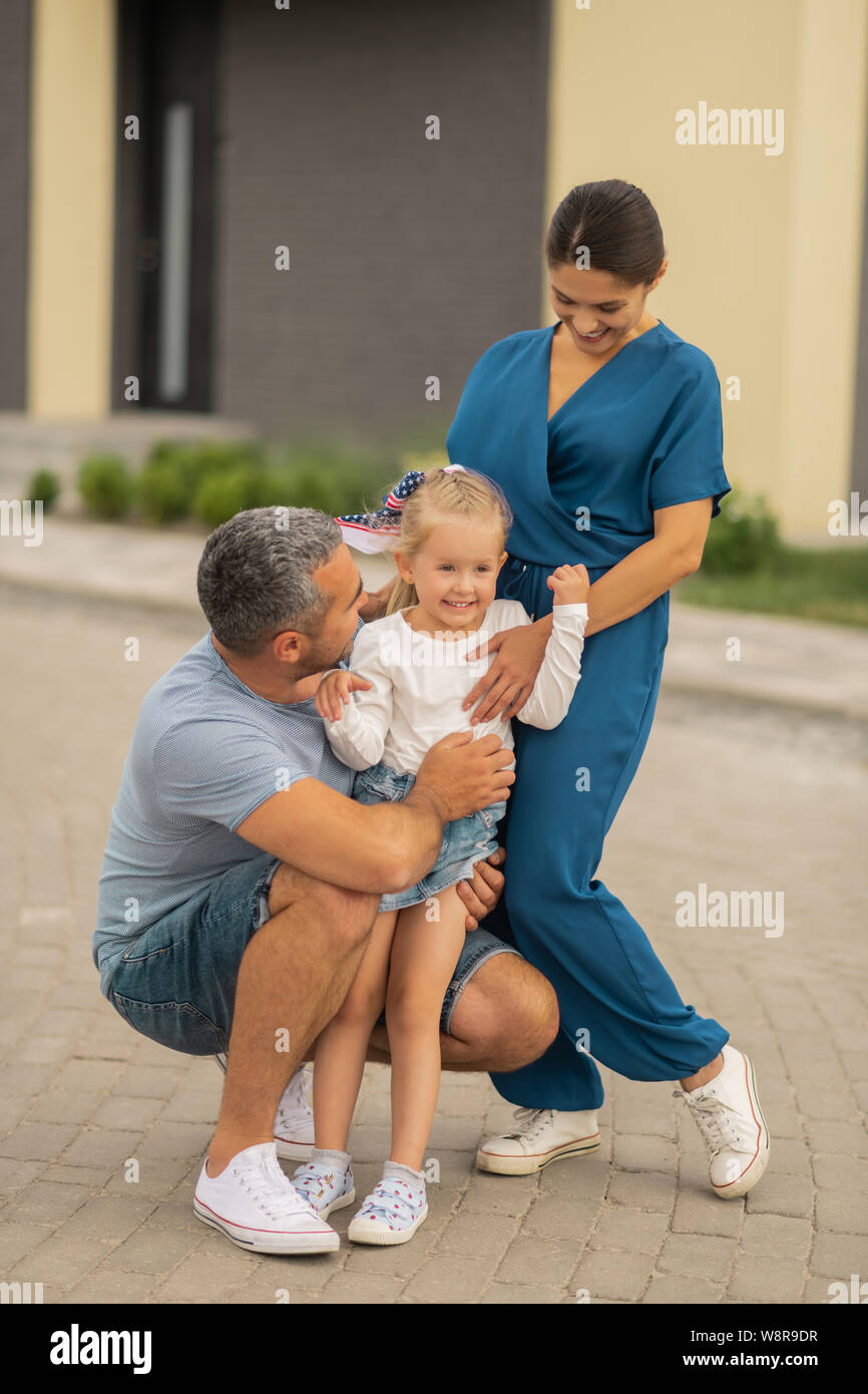 Loving parents hugging their beaming cute daughter Stock Photo - Alamy