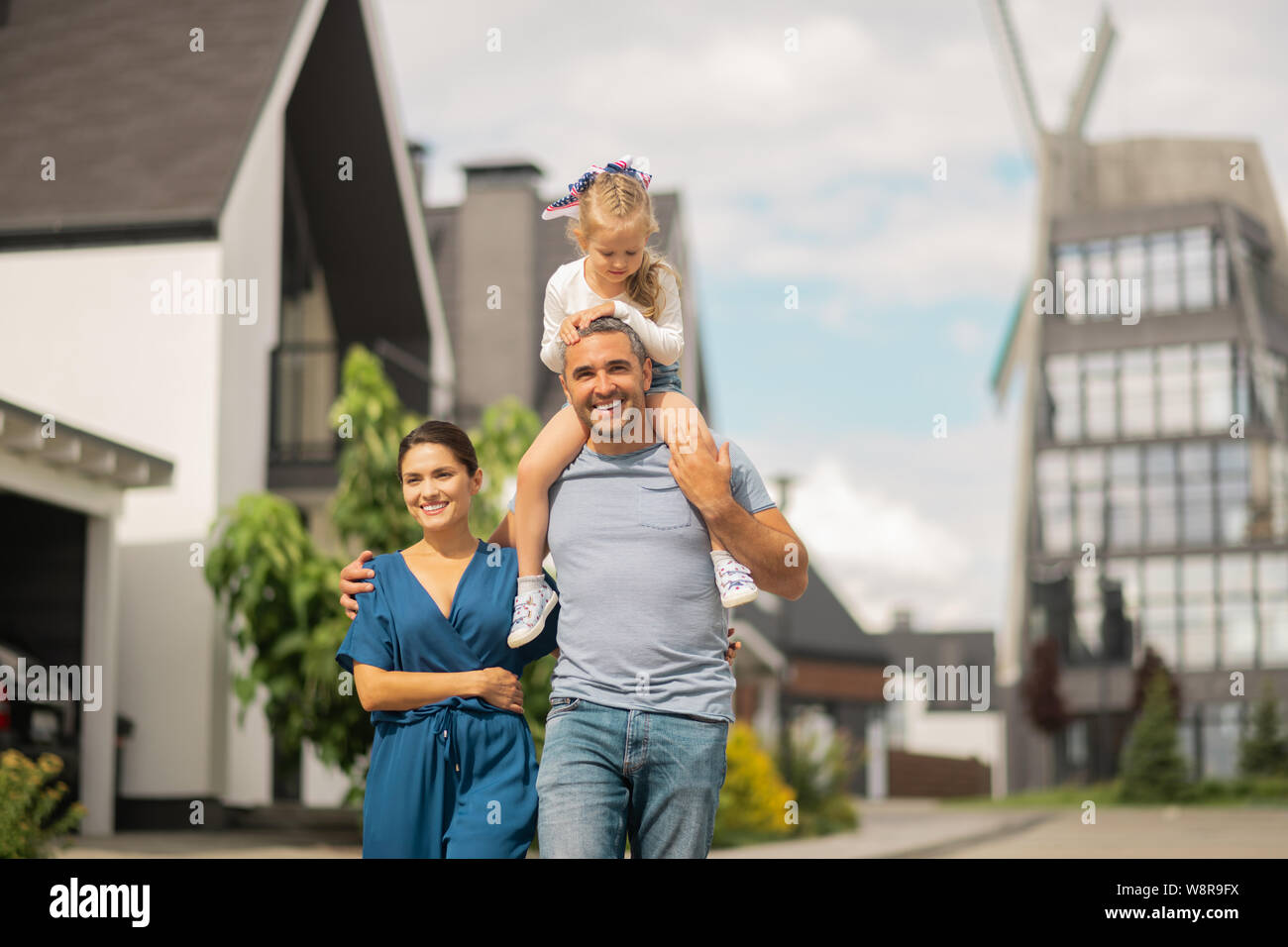 Daughter sitting on neck of father while having family walk Stock Photo ...
