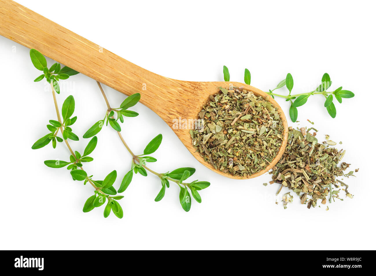 Dried thyme leaves in the wooden spoon, with fresh thyme isolated on white background. Top view ...