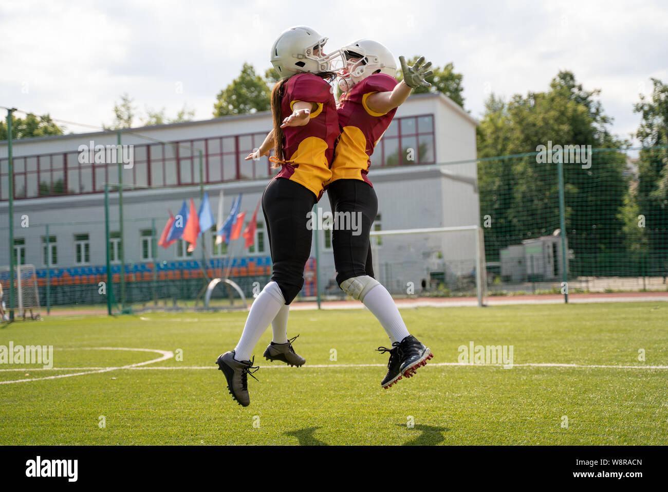 Photo of two rugby athletes jumping on playground Stock Photo - Alamy