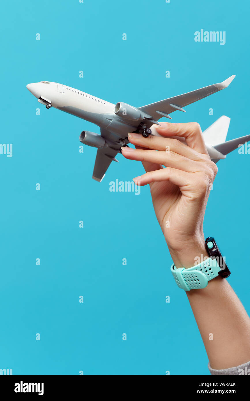 Image of hand with airplane on empty blue background Stock Photo - Alamy