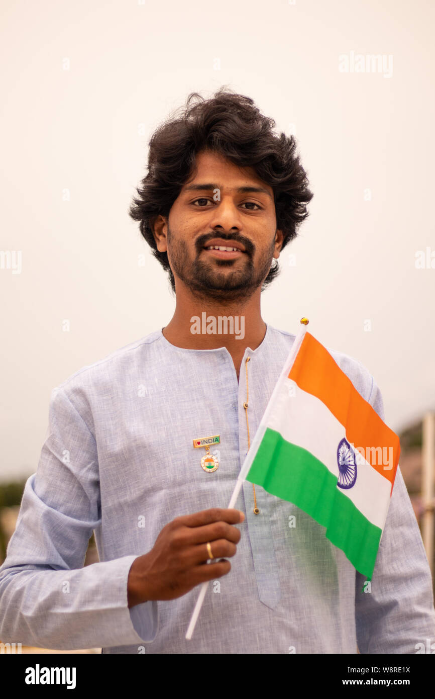 Portrait of a Young Indian man holding Indian flag in traditional ...