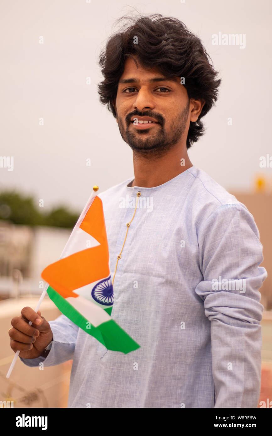 Portrait of a Young Indian man holding Indian flag in traditional ...