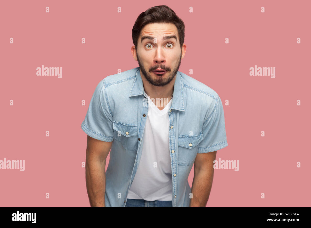 Portrait of surprised handsome bearded young man in blue casual style ...