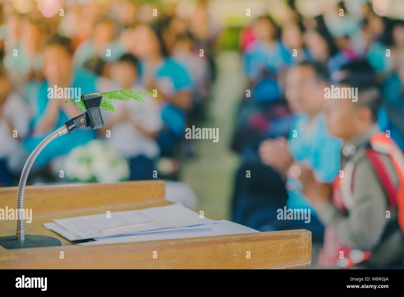 Artificial leaf inserted in the desktop microphone stand on podium in ...